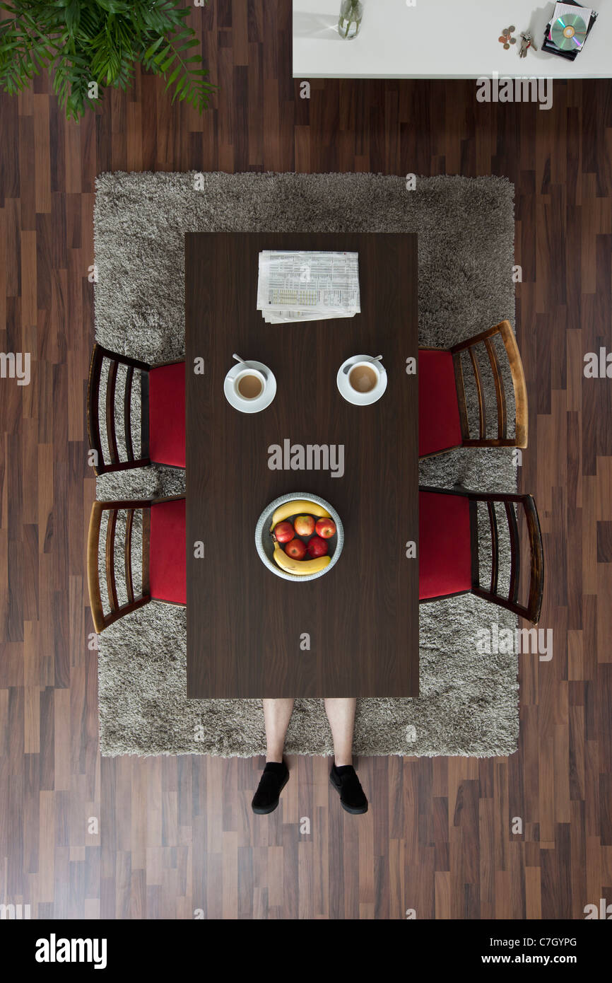 A man's feet sticking out of the bottom of a table, overhead view Stock ...