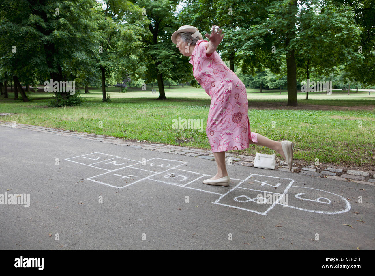 Senior woman playing hopscotch Stock Photo - Alamy