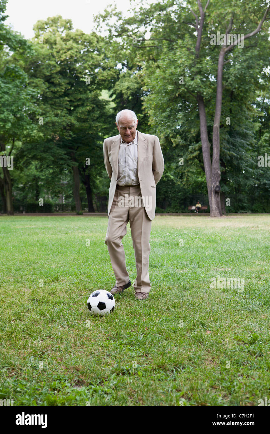 Senior man relaxed and playing football in park Stock Photo - Alamy