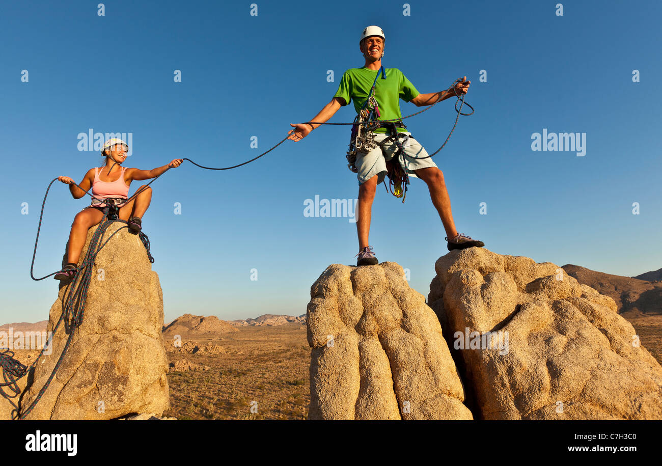 Team of rock climbers struggle to the summit of a challenging cliff ...