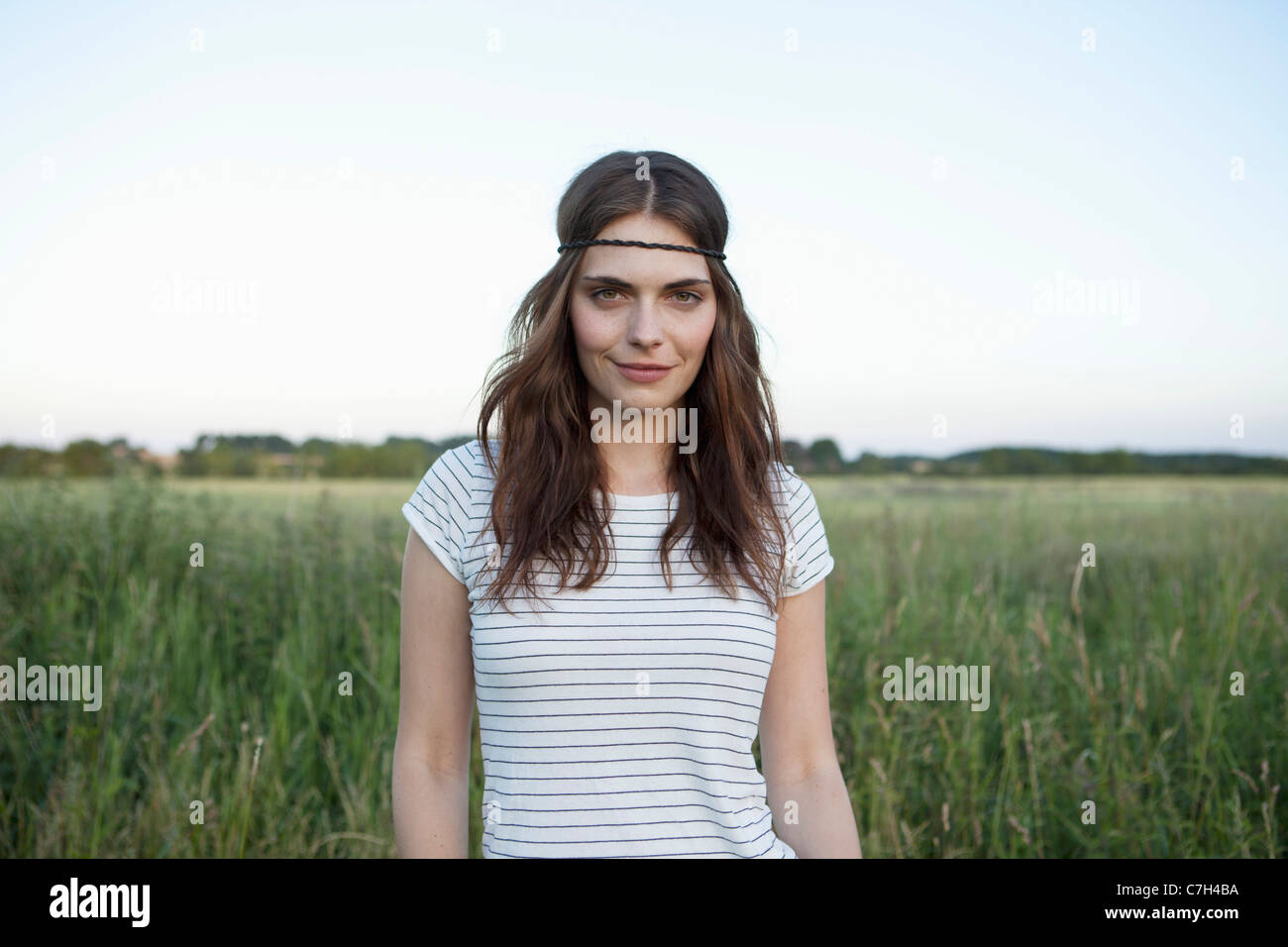 profile of girl with hair band standing in secluded field Stock Photo ...