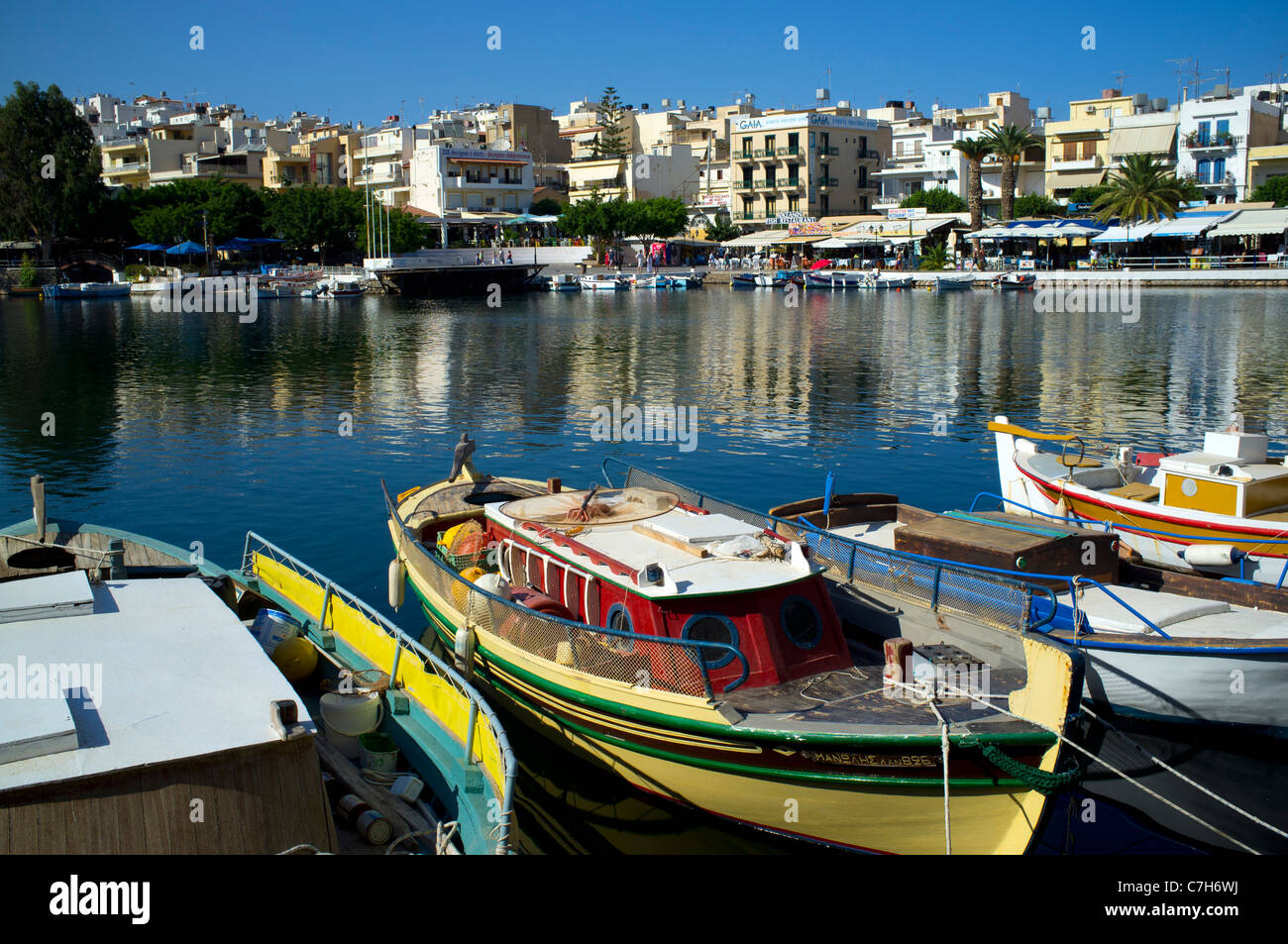 Colourful traditional fishing boats line Lake Voulismeni in Agios ...