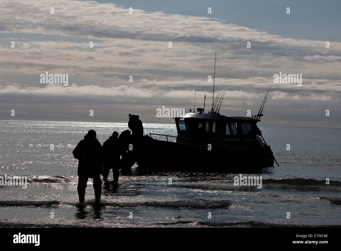 Group of male adults disembark from a boat along a beach, Cook Inlet ...