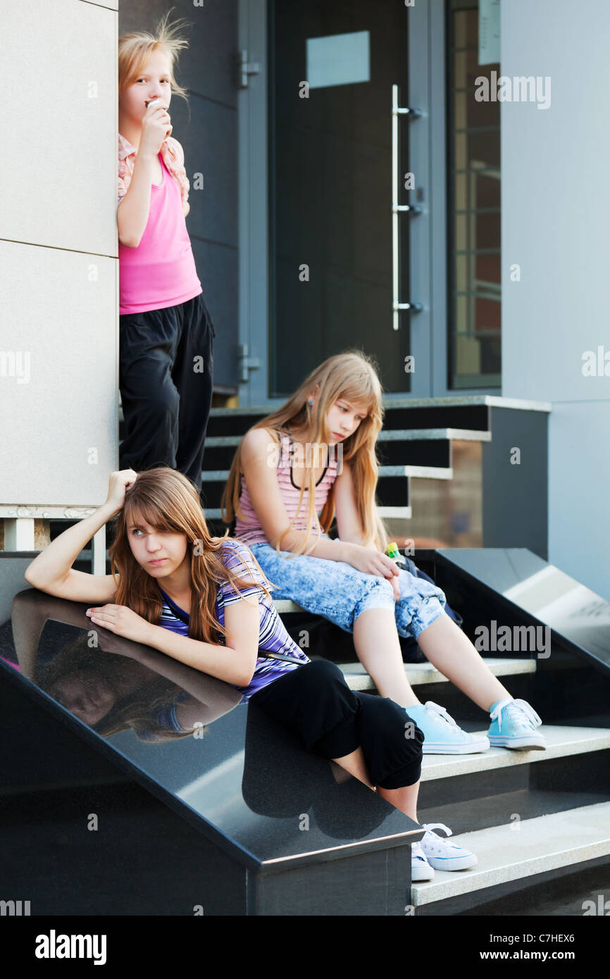 Teenage girls relaxing on a shop steps Stock Photo - Alamy