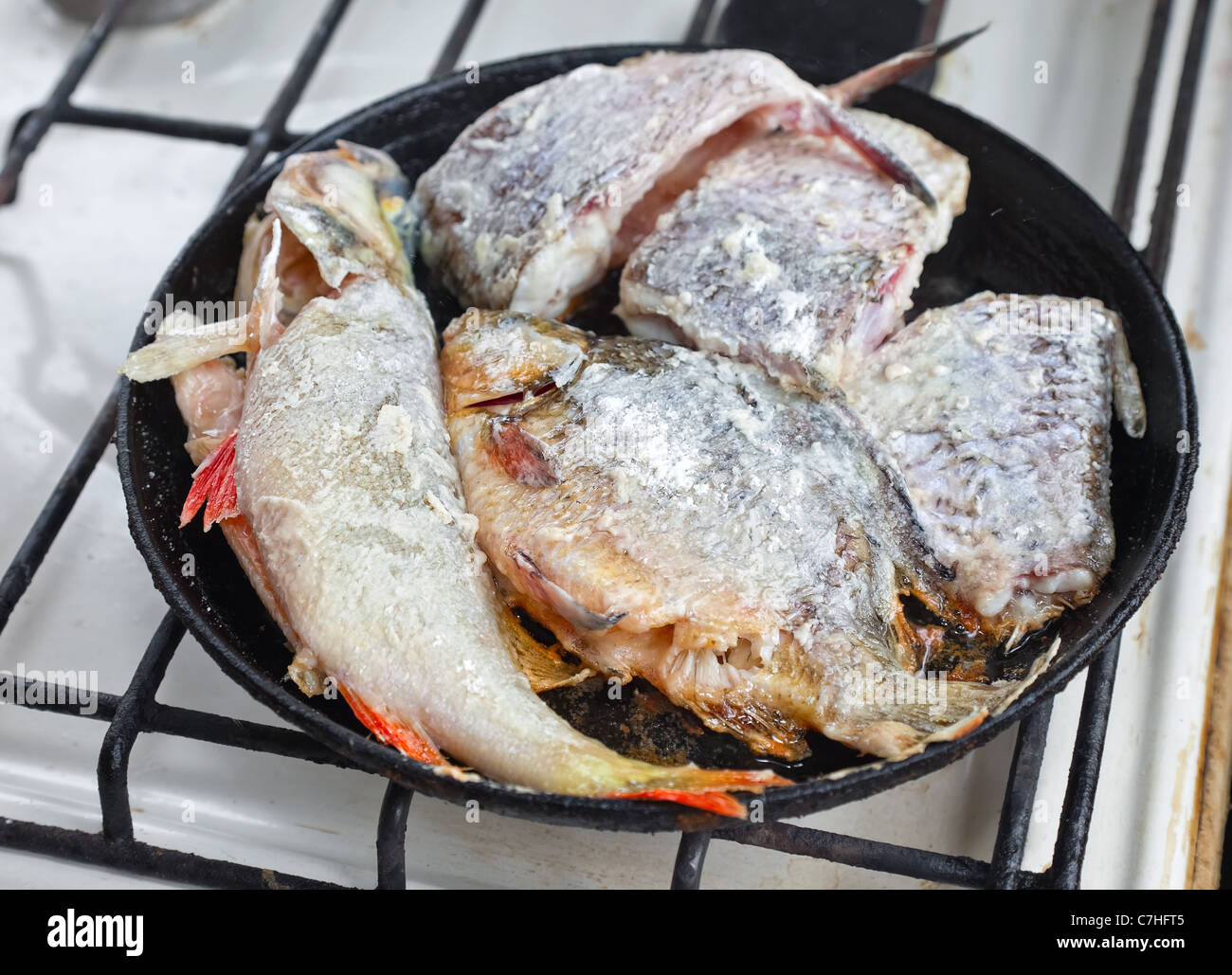 Fried fish in a frying pan Stock Photo - Alamy