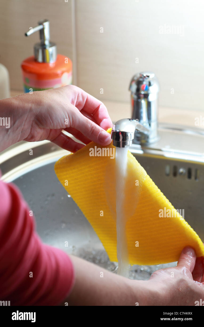 yellow cloth and hands under running water Stock Photo - Alamy
