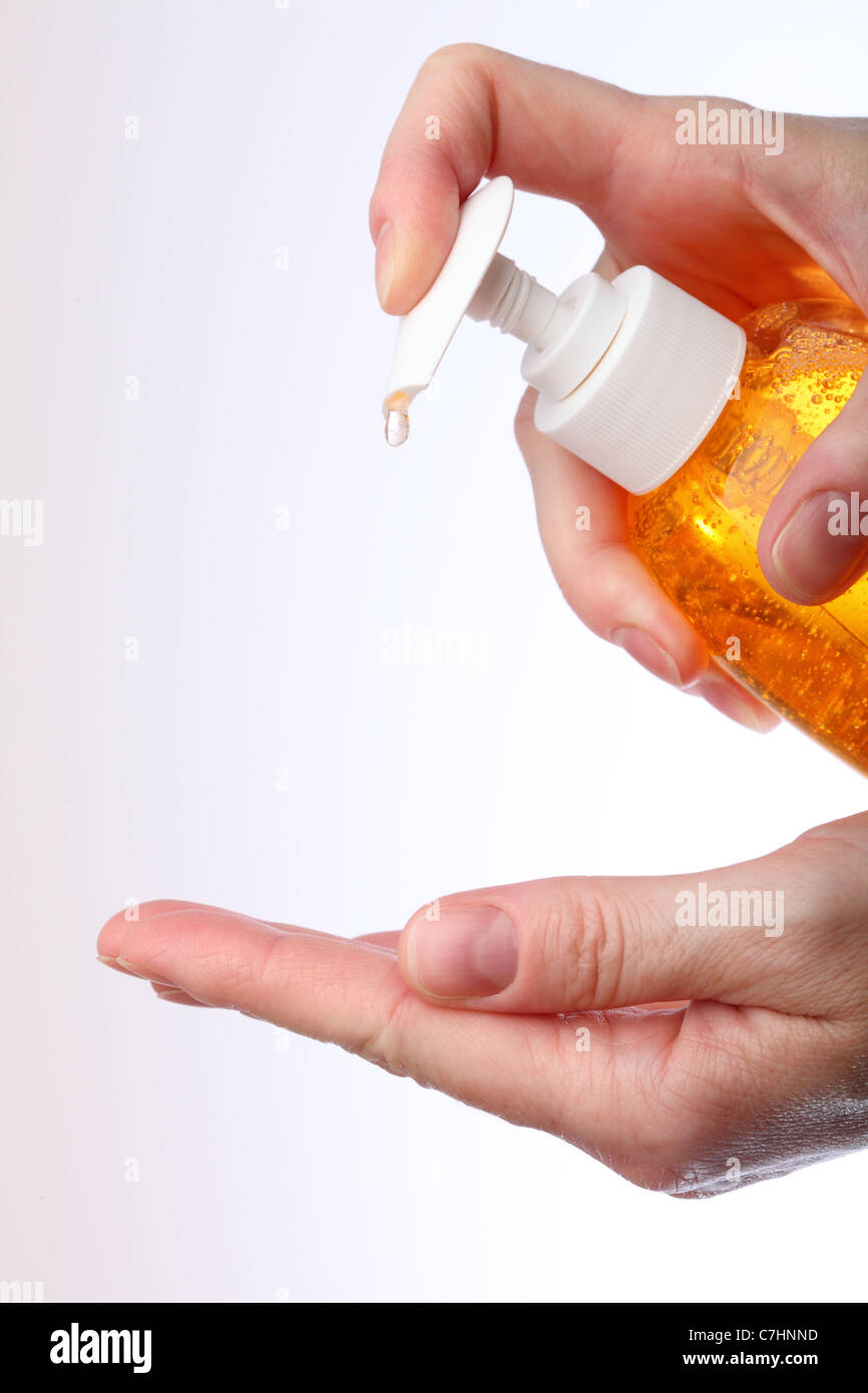 Applying liquid soap. Two hands holding bottle with liquid soap ...