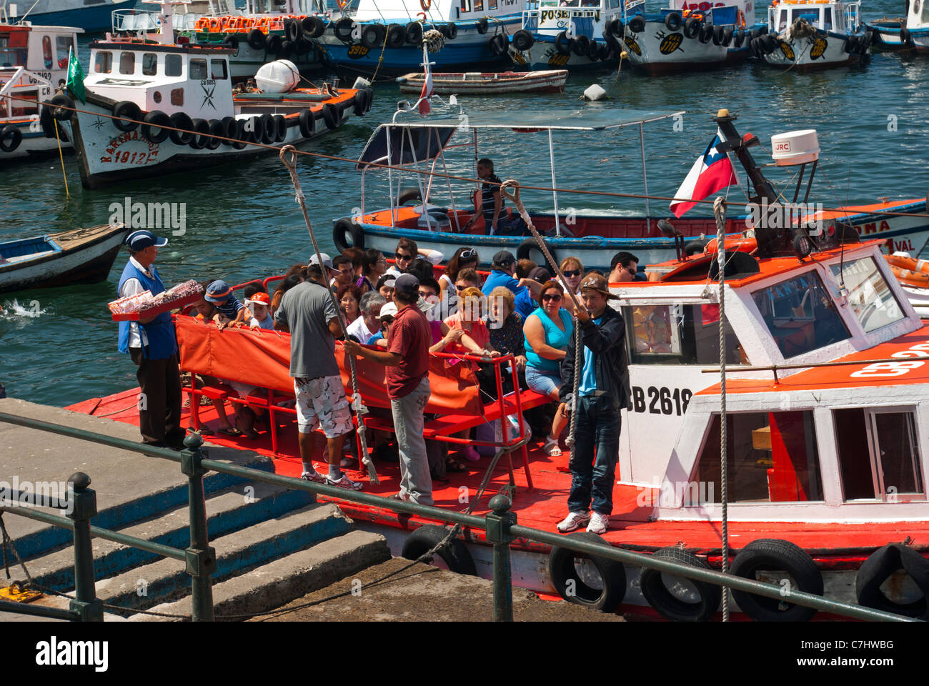 Passengers crowd into orange and white boats for harbor tour Stock ...