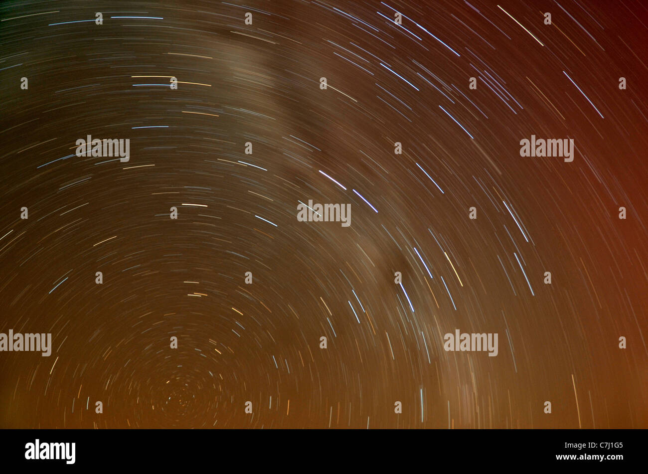 Long exposure Star Trails with yellow shine from city in the desert ...
