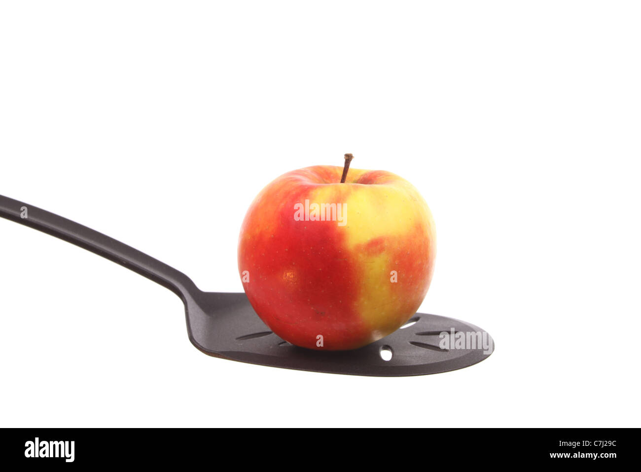 Apple on a spoon against a white background Stock Photo - Alamy