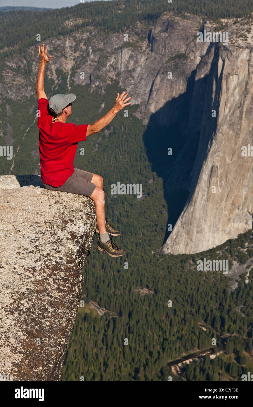 Male rock climber celebrates on the summit after a successful ascent ...