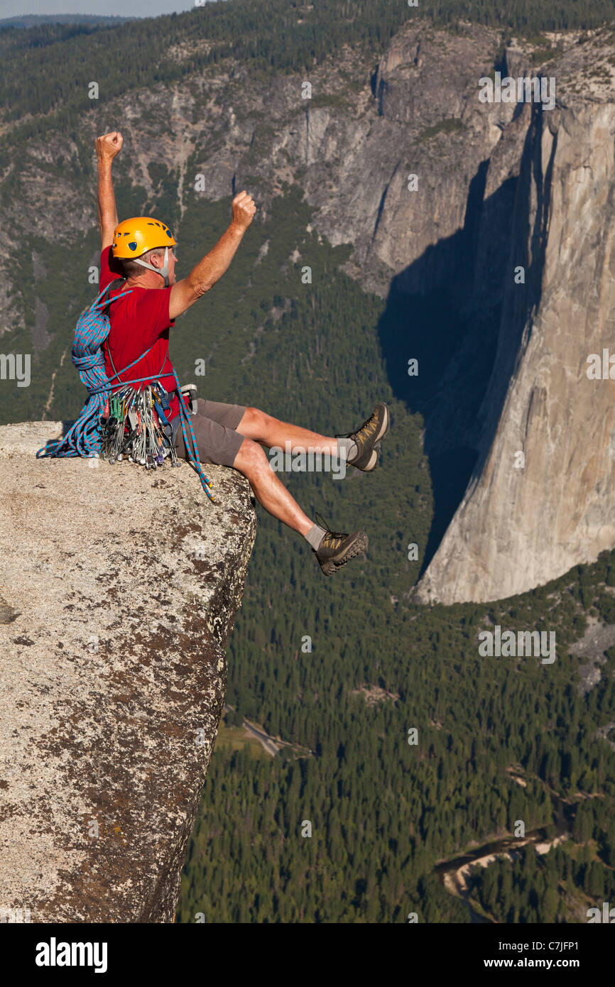 Male rock climber celebrates on the summit after a successful ascent ...