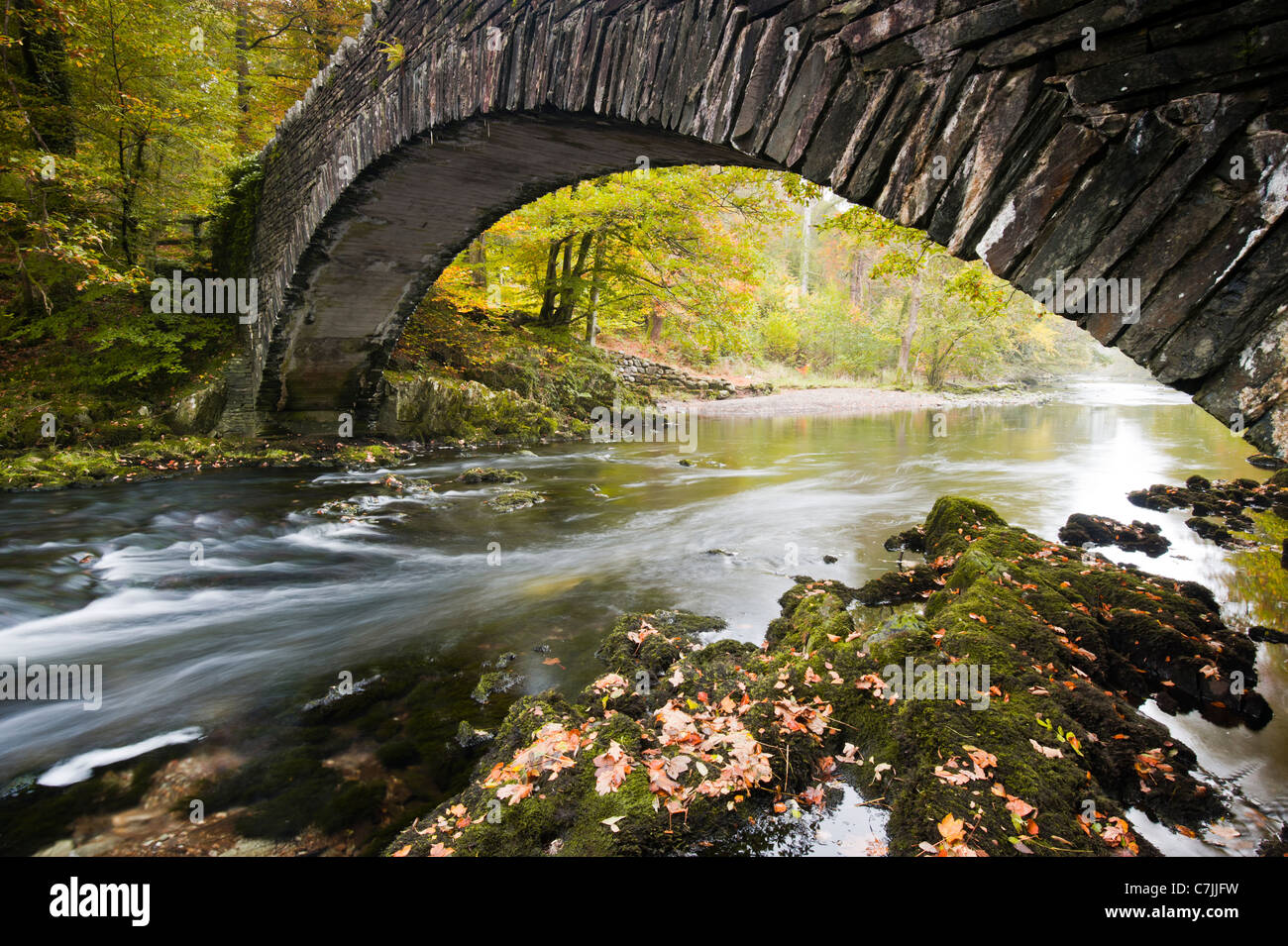 Stone footbridge over a small river in Autumn, Lake District, England ...
