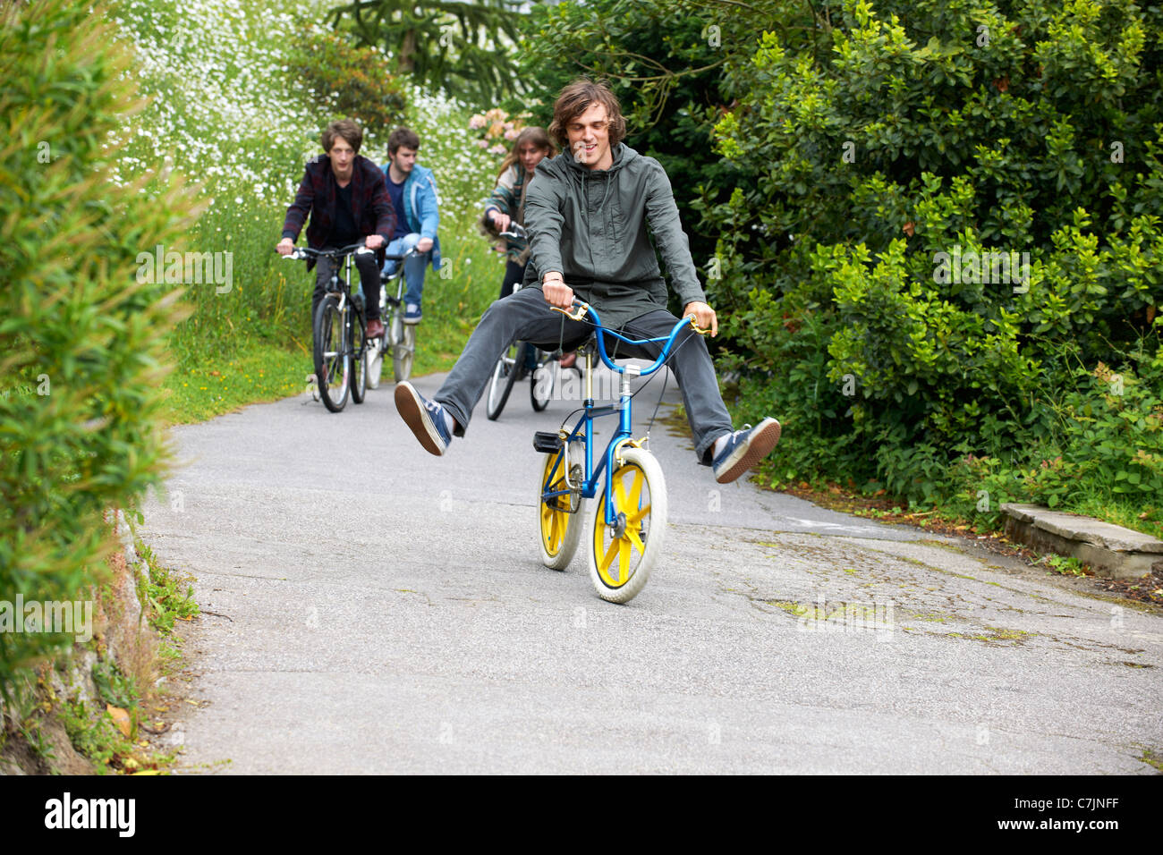 Teenagers riding bicycles in park Stock Photo - Alamy