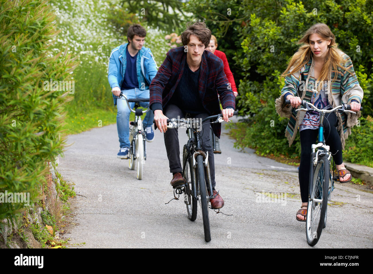 Teenagers riding bicycles in park Stock Photo - Alamy