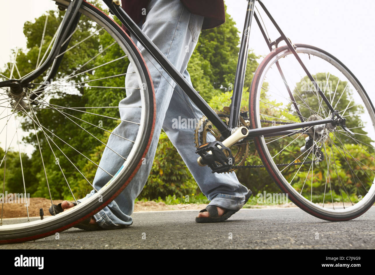 Close up of man walking bicycle Stock Photo - Alamy