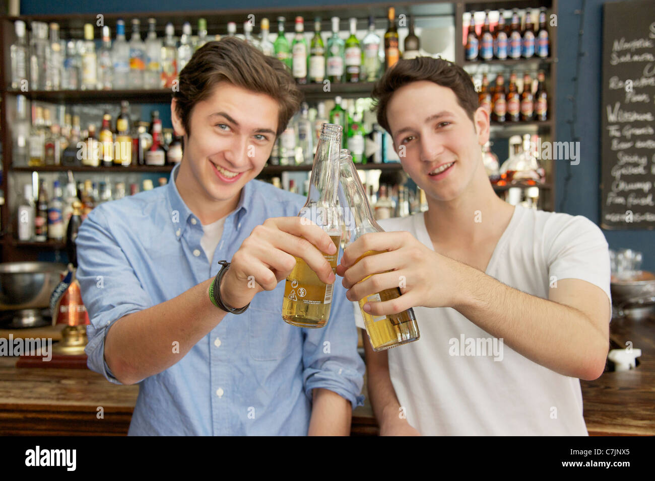 Men toasting each other in bar Stock Photo - Alamy