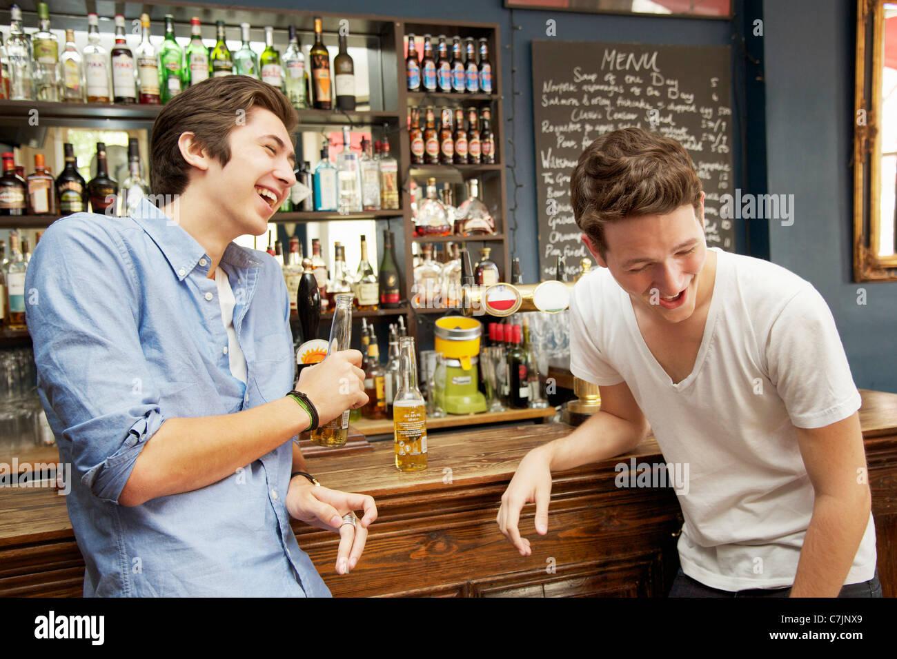 Smiling men drinking beers in bar Stock Photo - Alamy