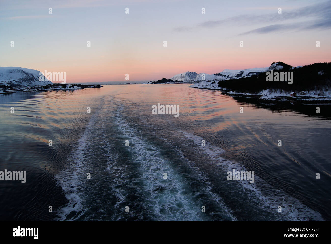 Norwegian Fjord at dawn with snow covered mountains and calm seas red ...