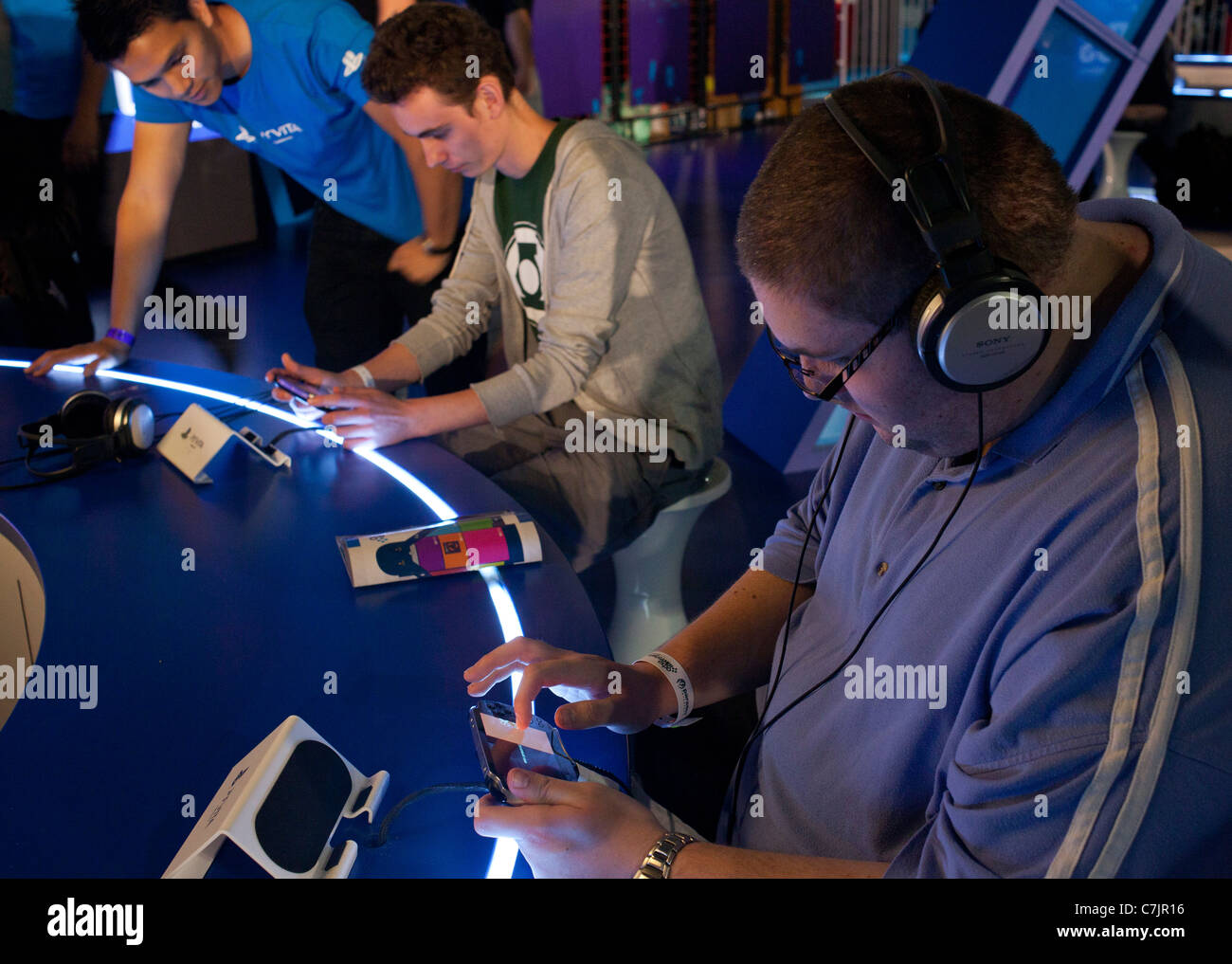 Young people trying latest Sony PS and console games at a trade fair in ...