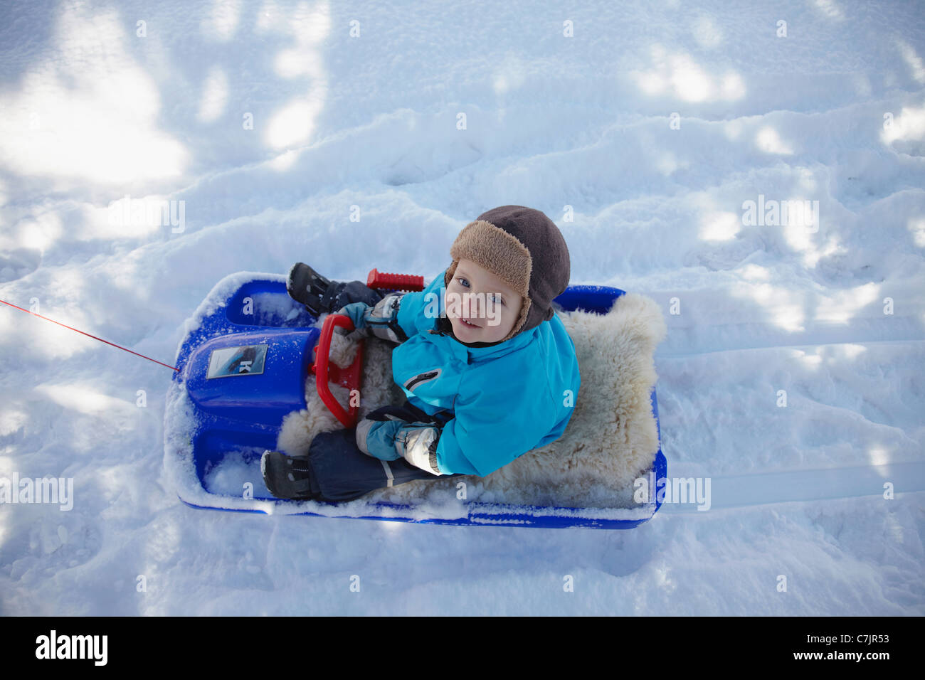 Child riding toy snowmobile in snow Stock Photo - Alamy