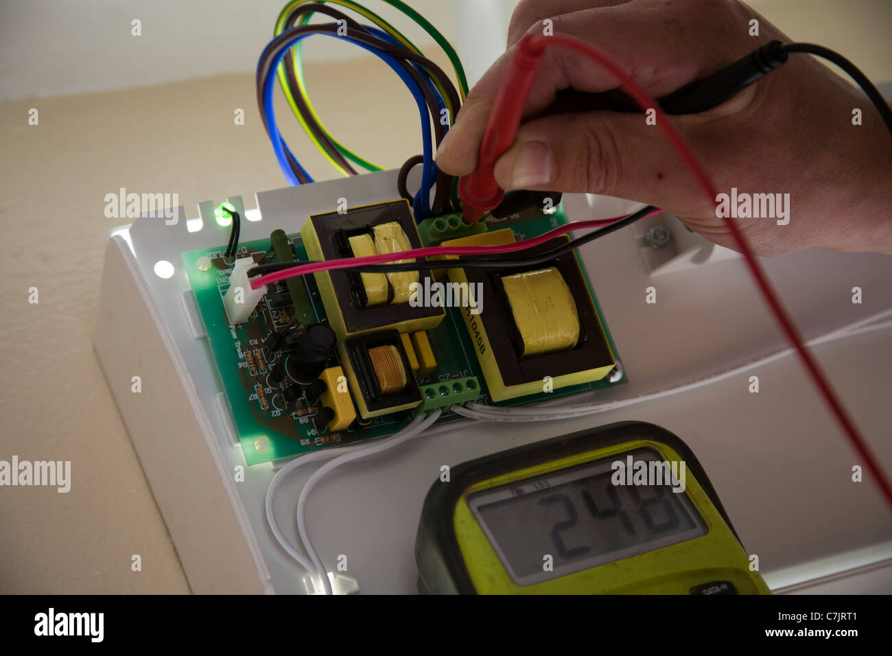 Electrican using Metering Equipment Fault finding on a Fire Alarm Panel ...