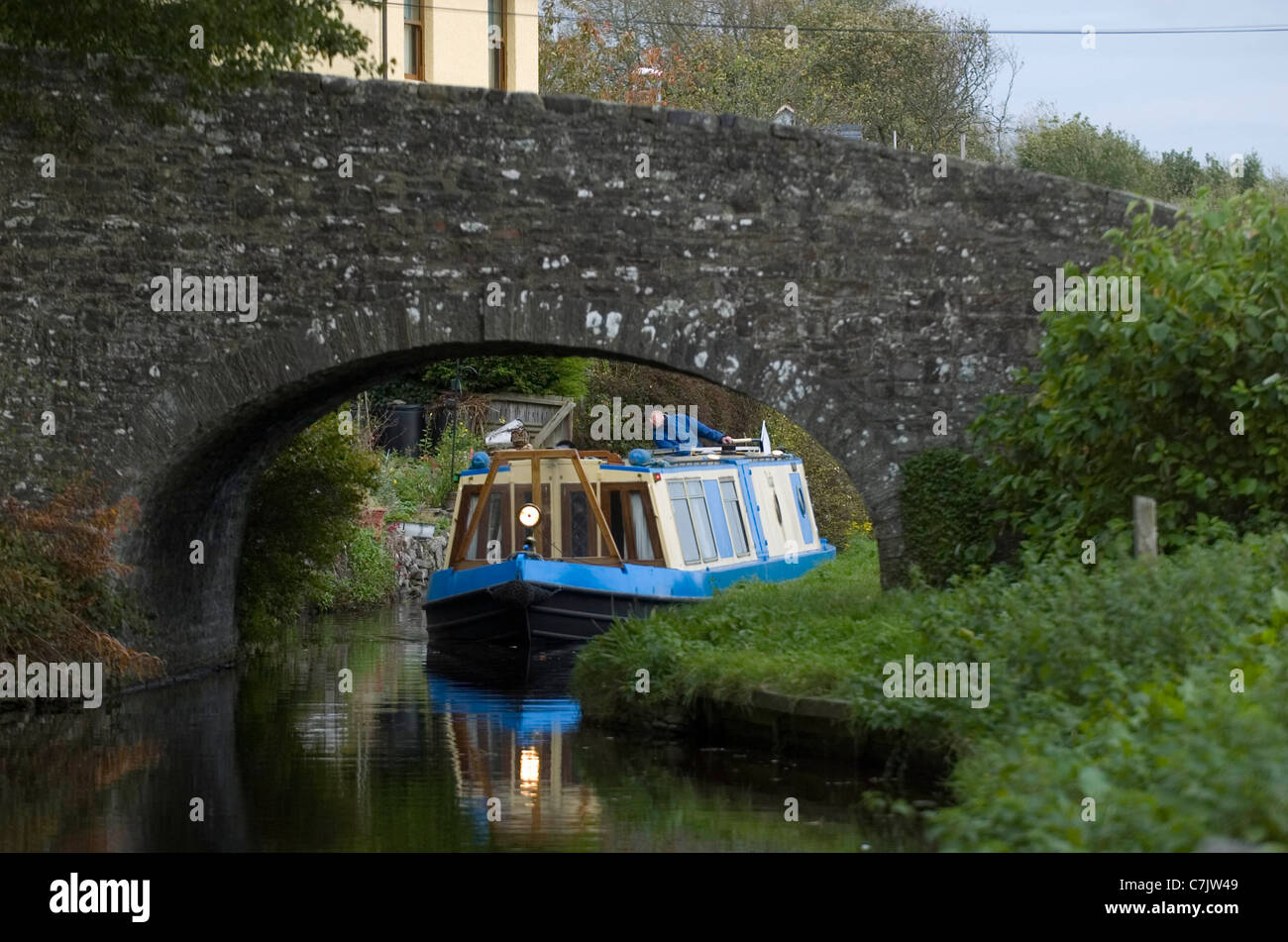 Barge making it's way under a low bridge on the Brecon canal in the mid ...