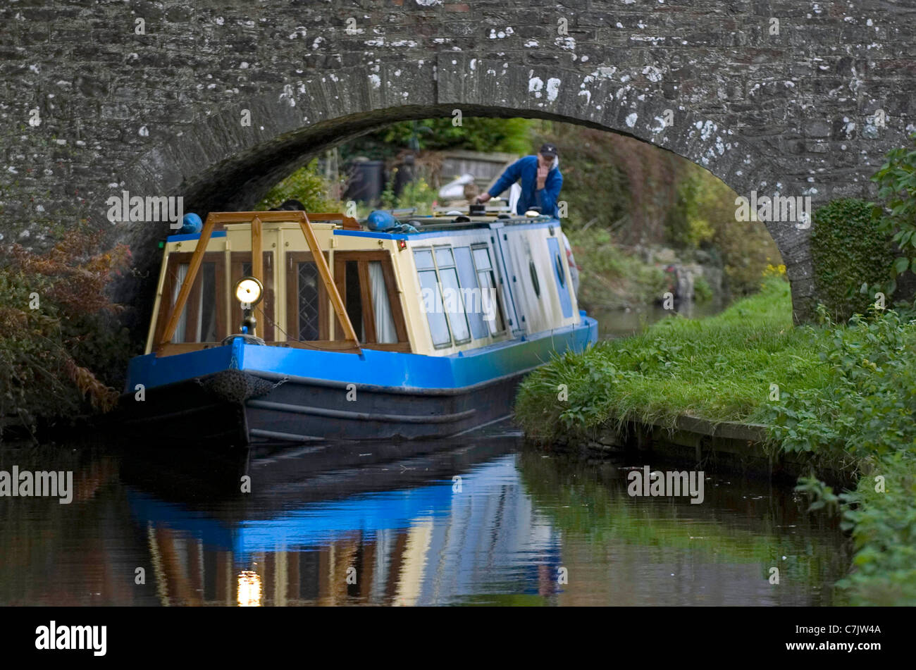 Barge making it's way under a low bridge on the Brecon canal in the mid ...