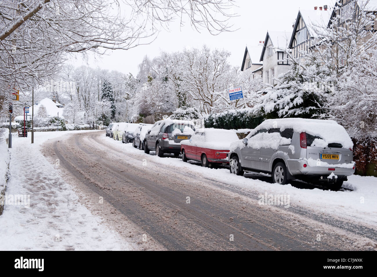 Winter village street (car tracks on quiet snow covered road, cars ...