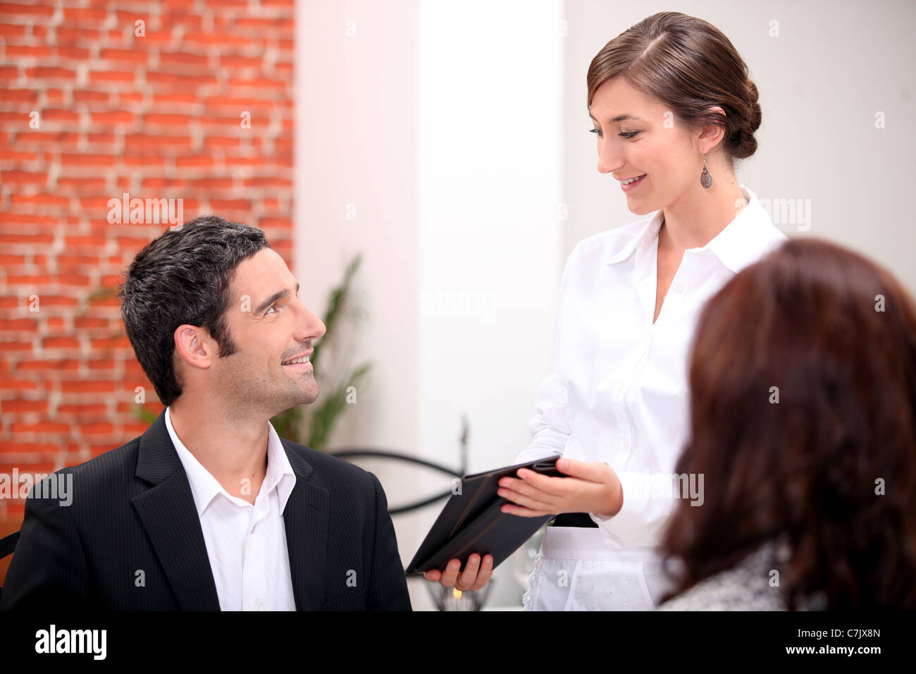 Waitress with menus in a restaurant Stock Photo - Alamy