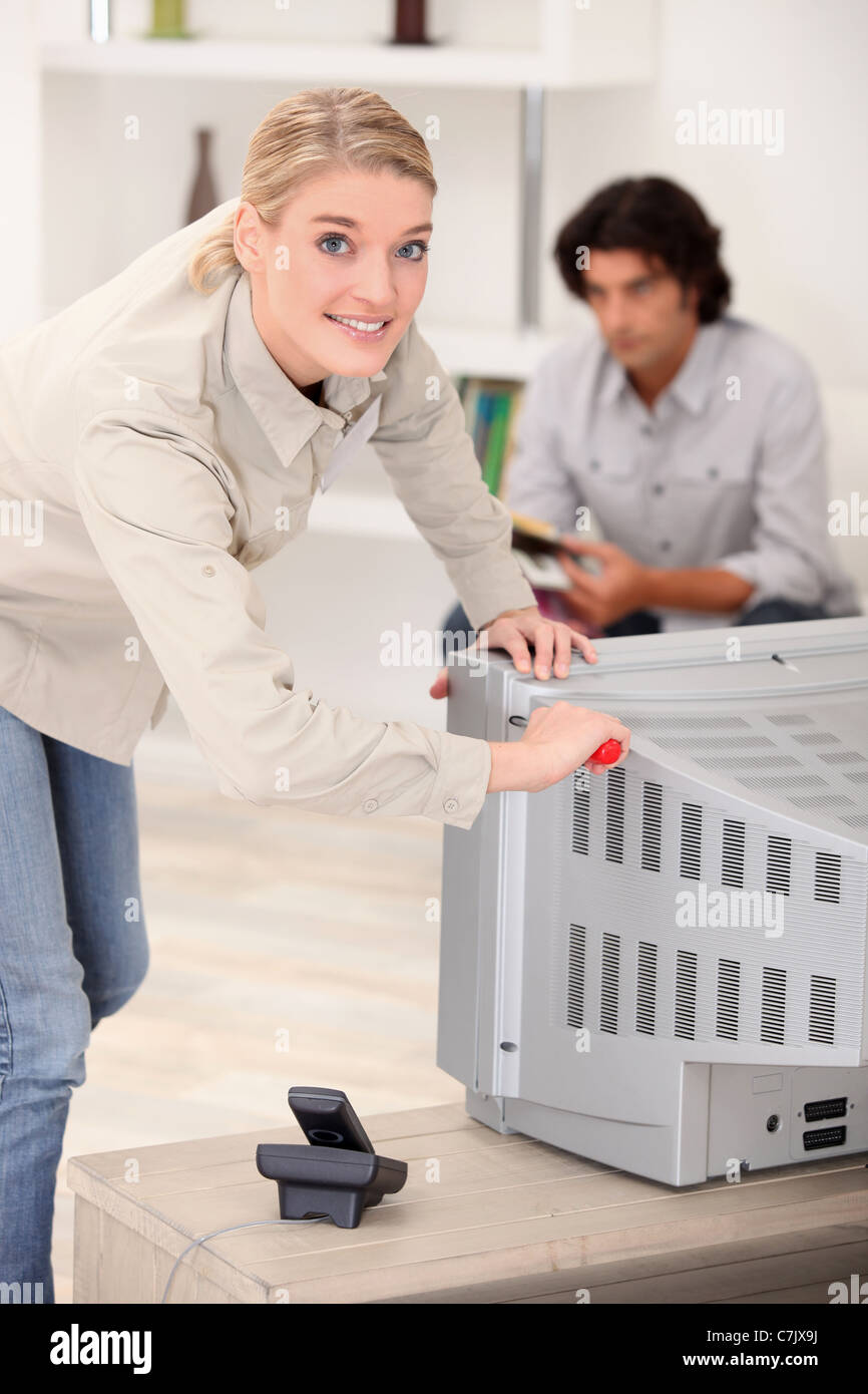 Woman removing the back of a tv set Stock Photo - Alamy