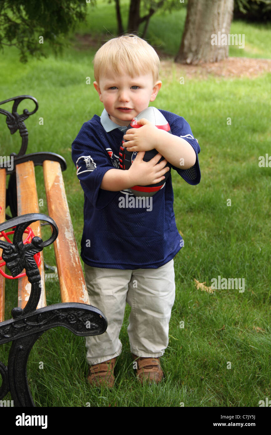 toddler boy holds football ready to play Stock Photo - Alamy