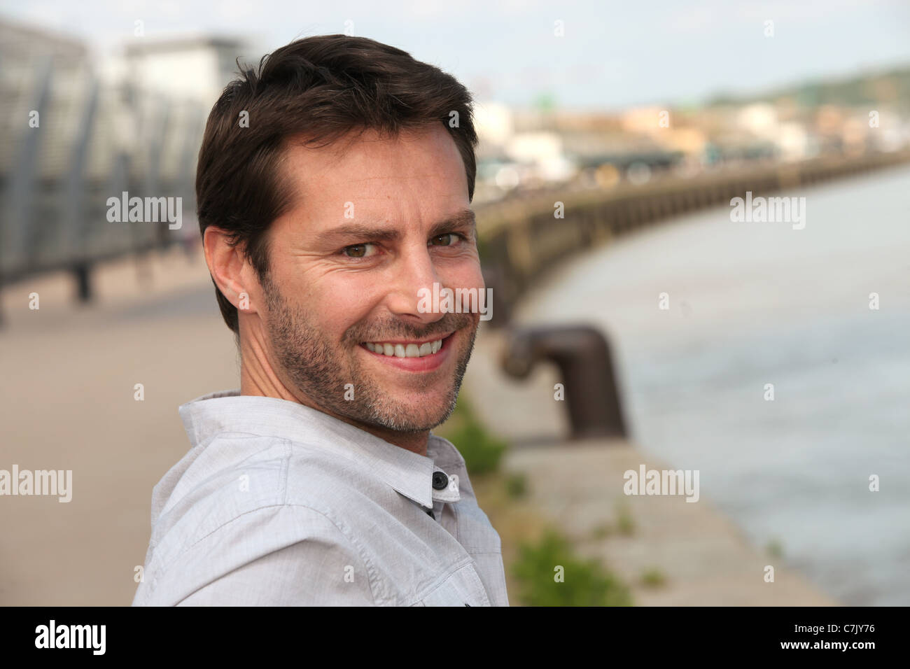 Man smiling next to the river Stock Photo - Alamy