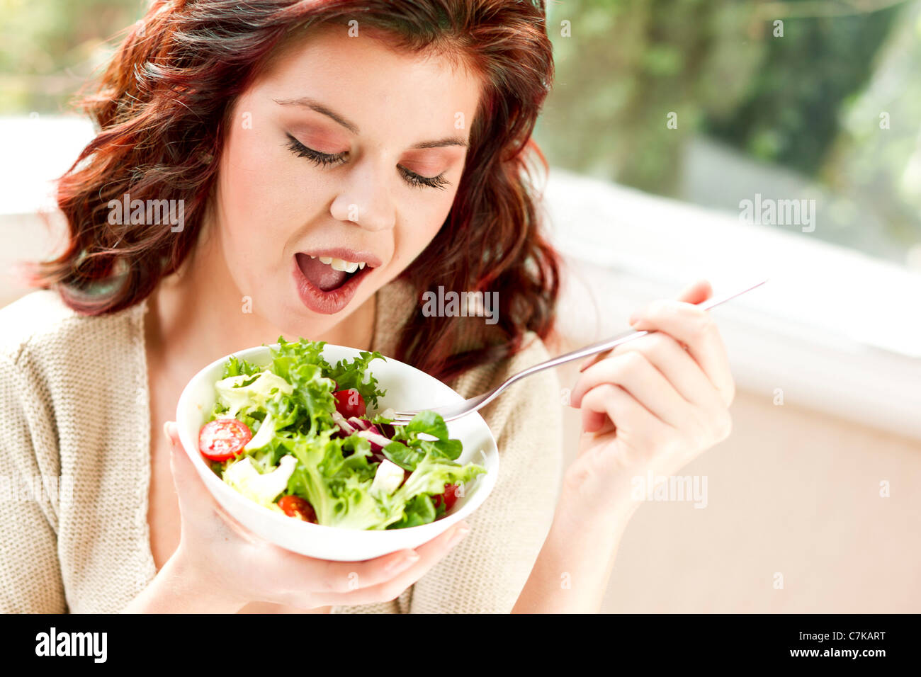 Girl eating salad Stock Photo - Alamy