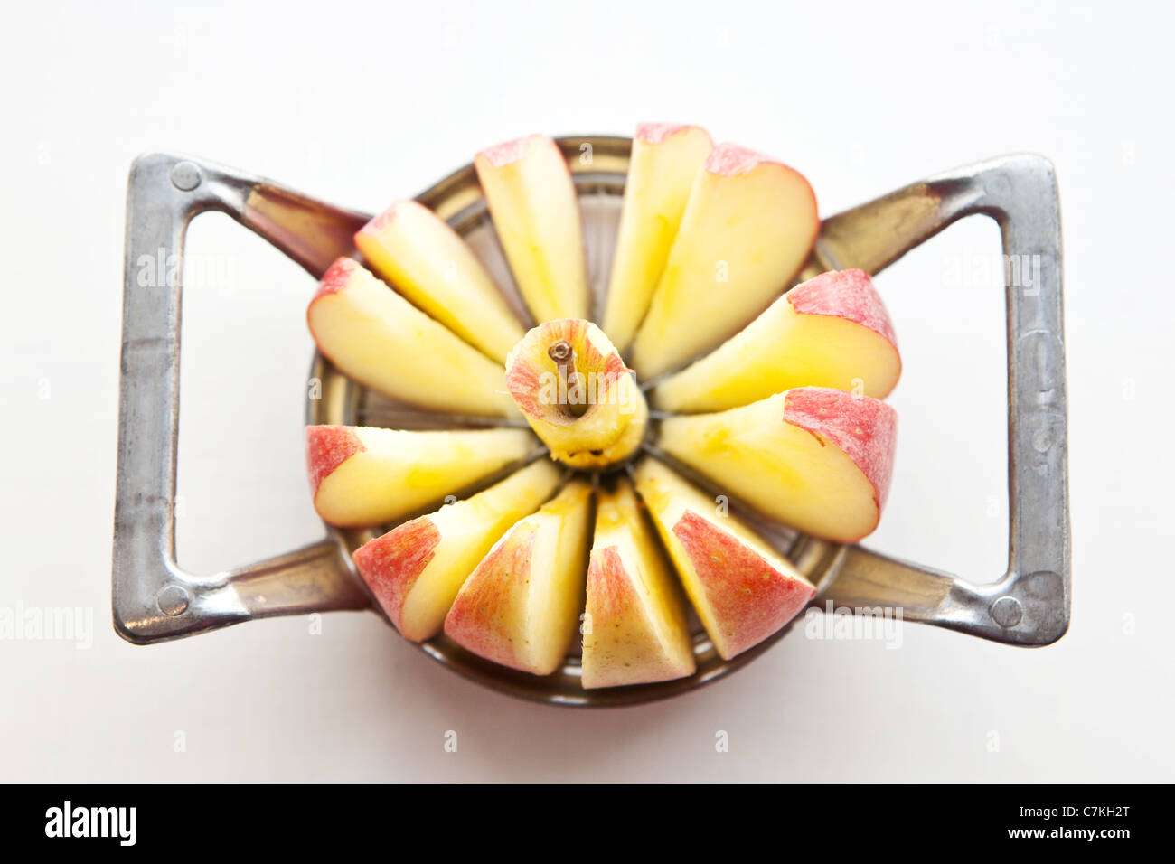 An apple corer with a sliced red apple against a white background Stock ...
