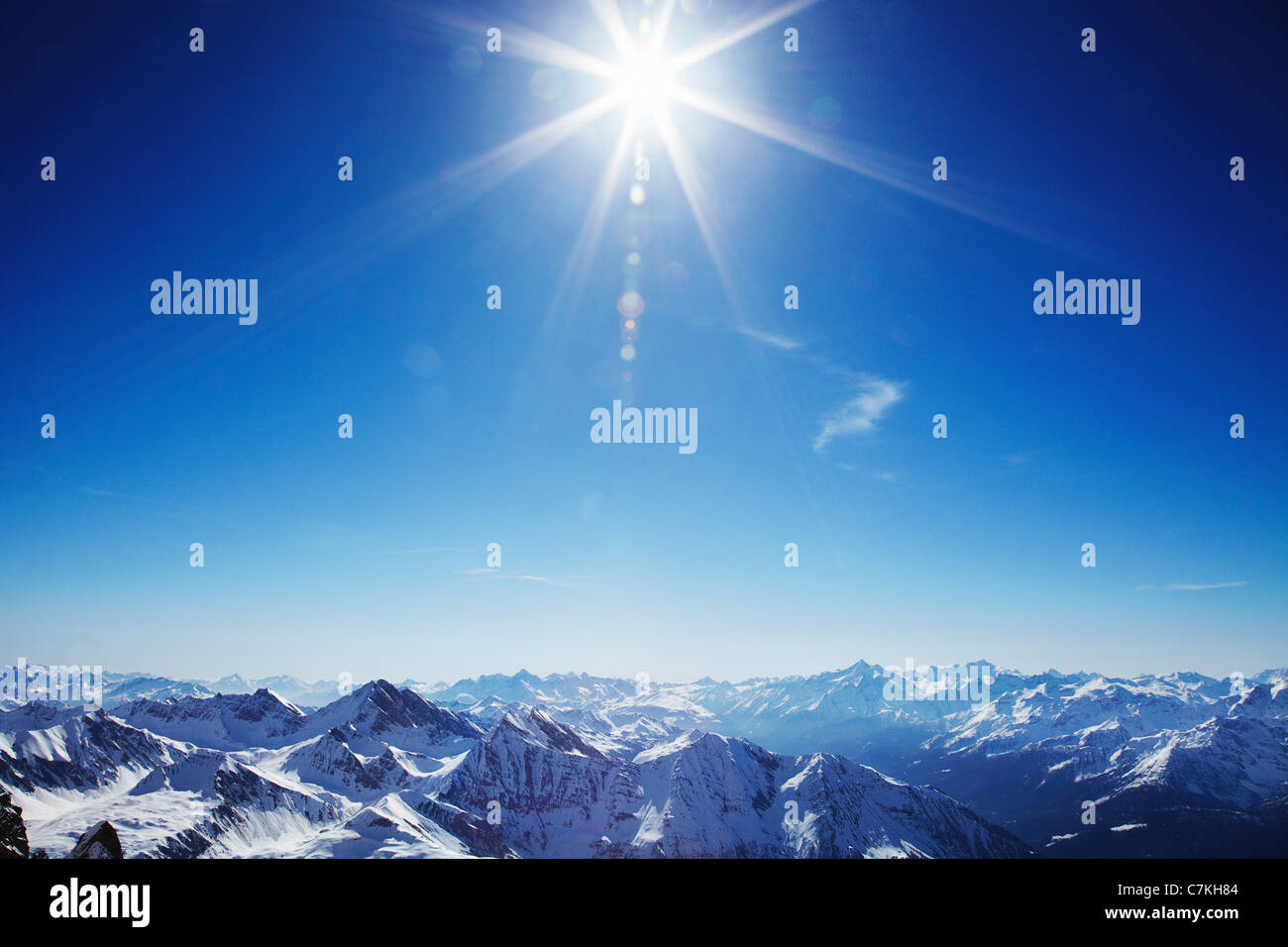 Sun over snow covered mountains Stock Photo - Alamy