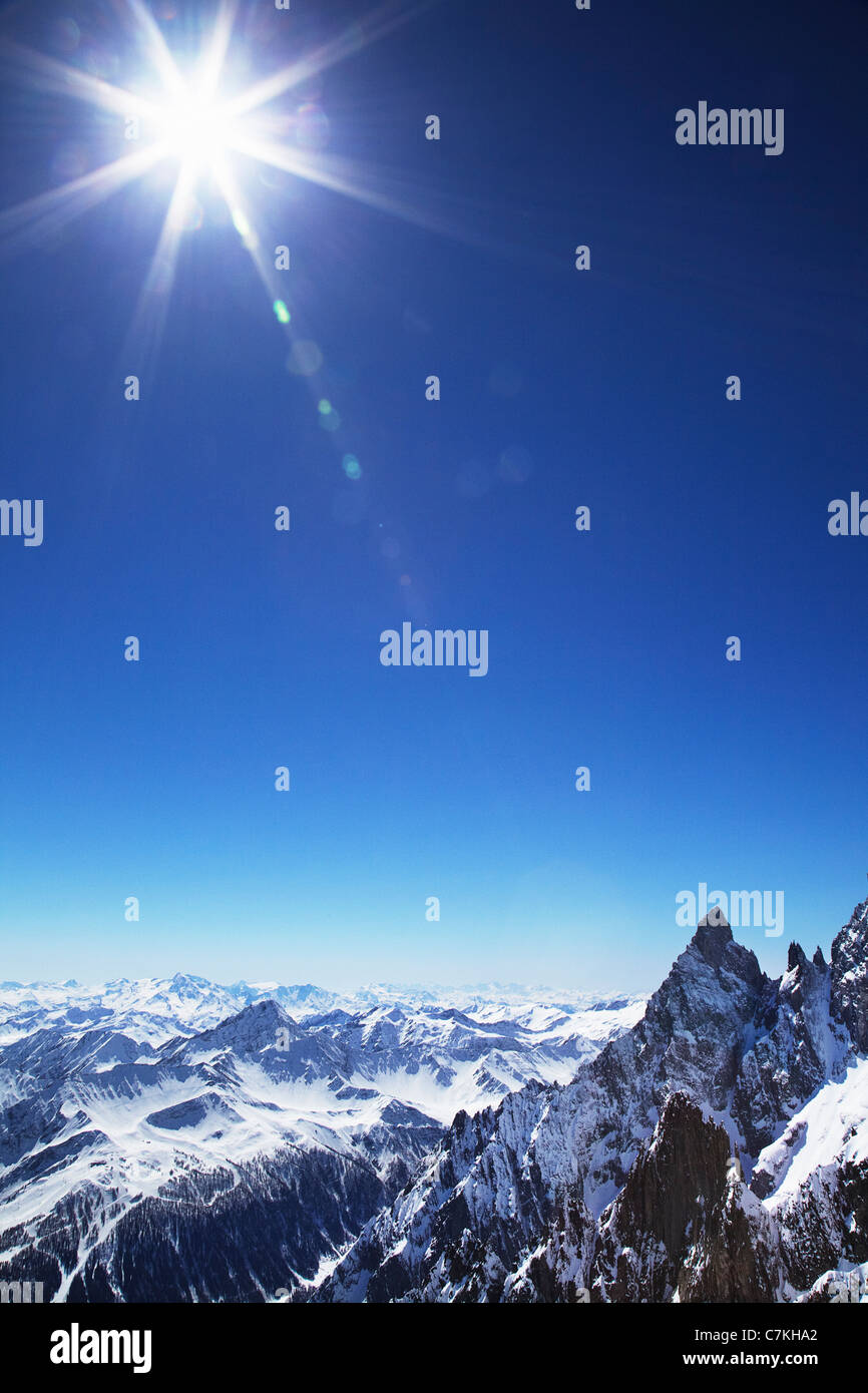 Sun over snow covered mountains Stock Photo - Alamy