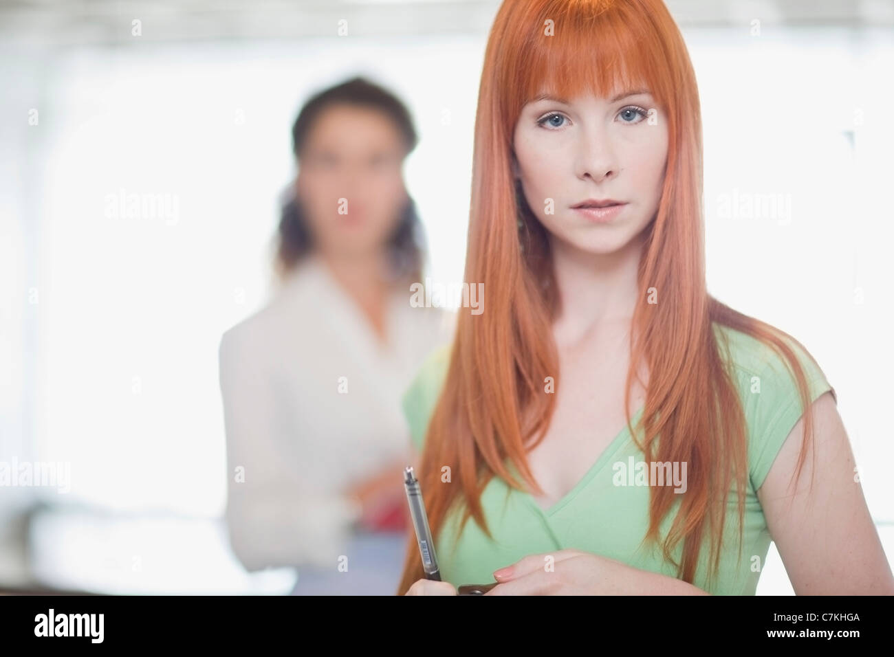 Red-haired woman holding pen Stock Photo - Alamy