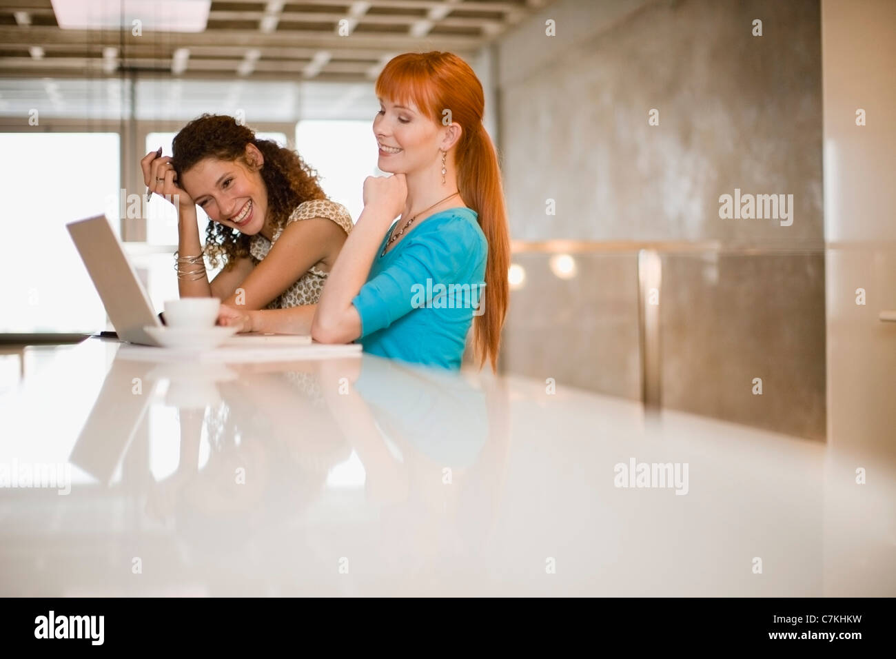 Businesswomen using laptop together Stock Photo - Alamy