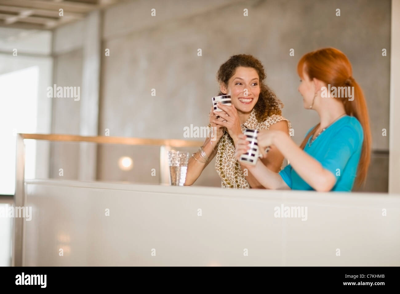 Smiling women having coffee together Stock Photo - Alamy
