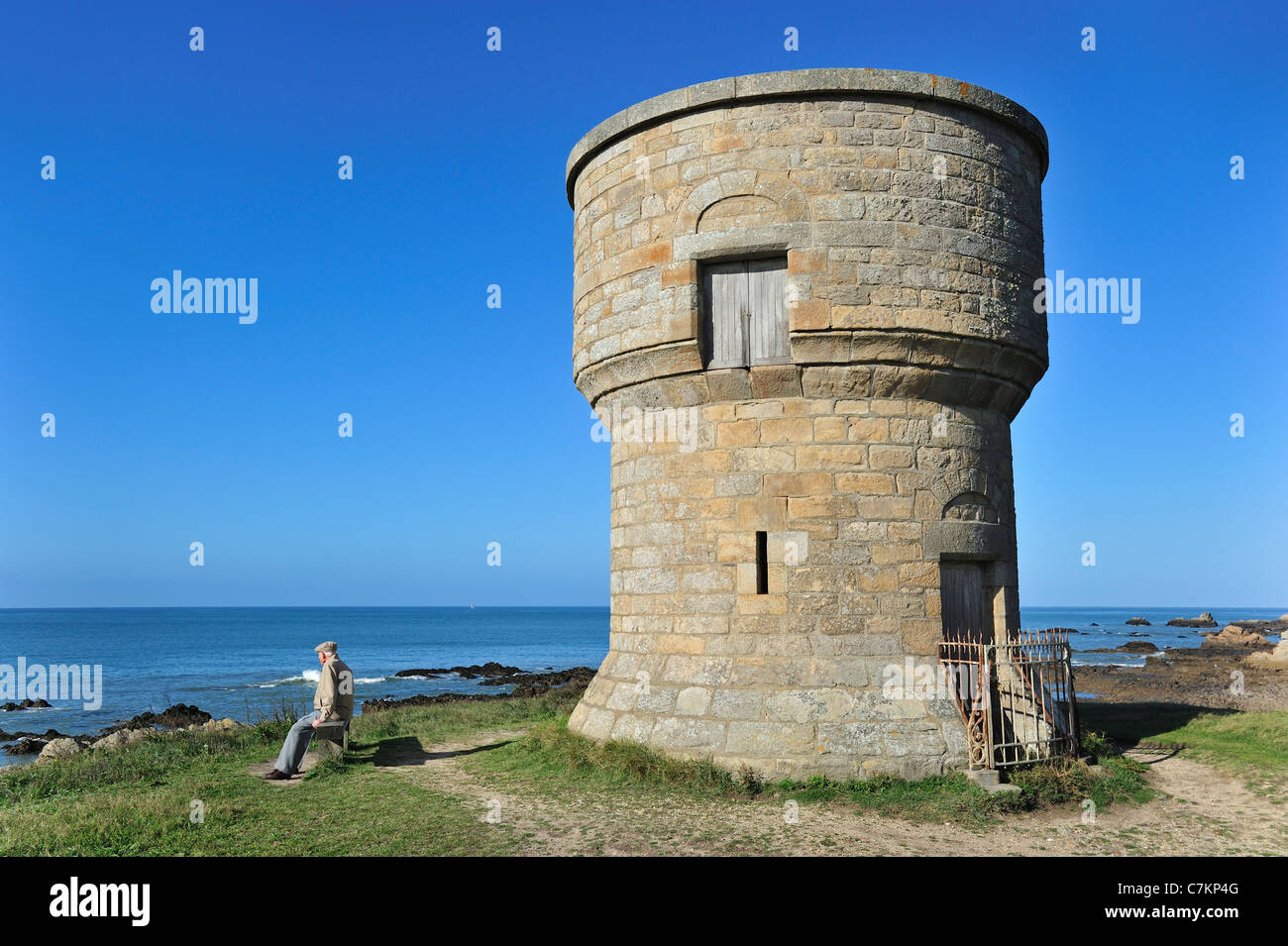 Old man looking at the sea and watchtower along the Côte Sauvage near ...