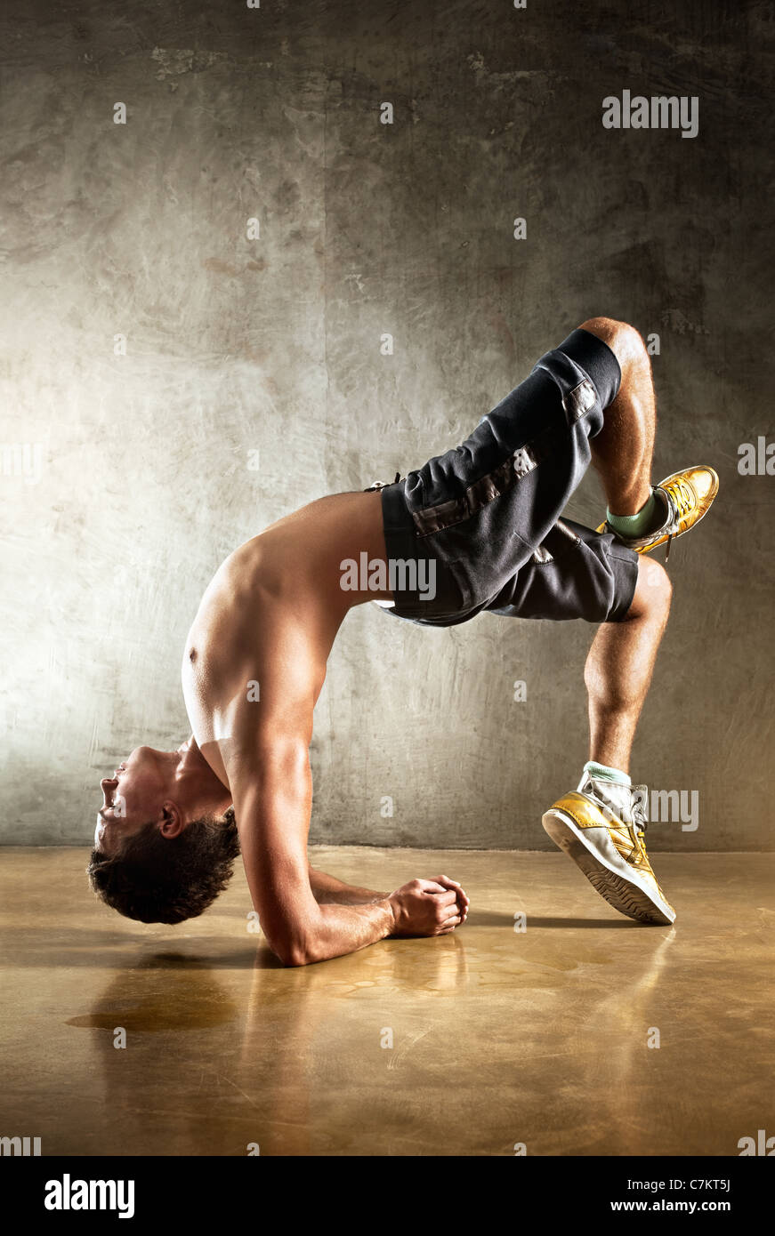 Young man sports exercises. On wall background Stock Photo - Alamy