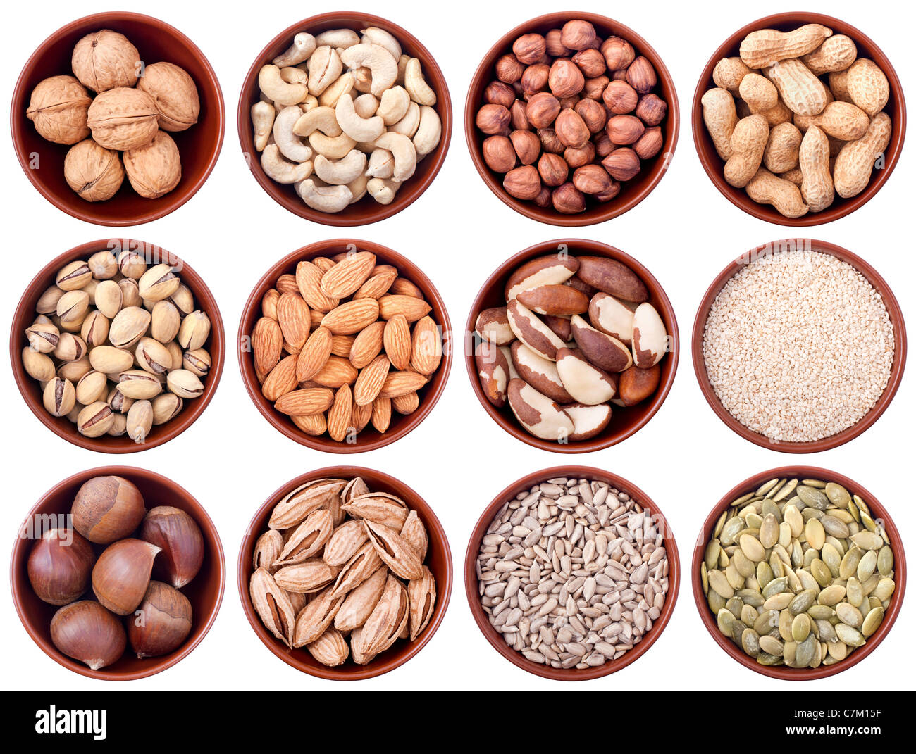 assortment of nuts and seeds in ceramic bowls isolated on white ...