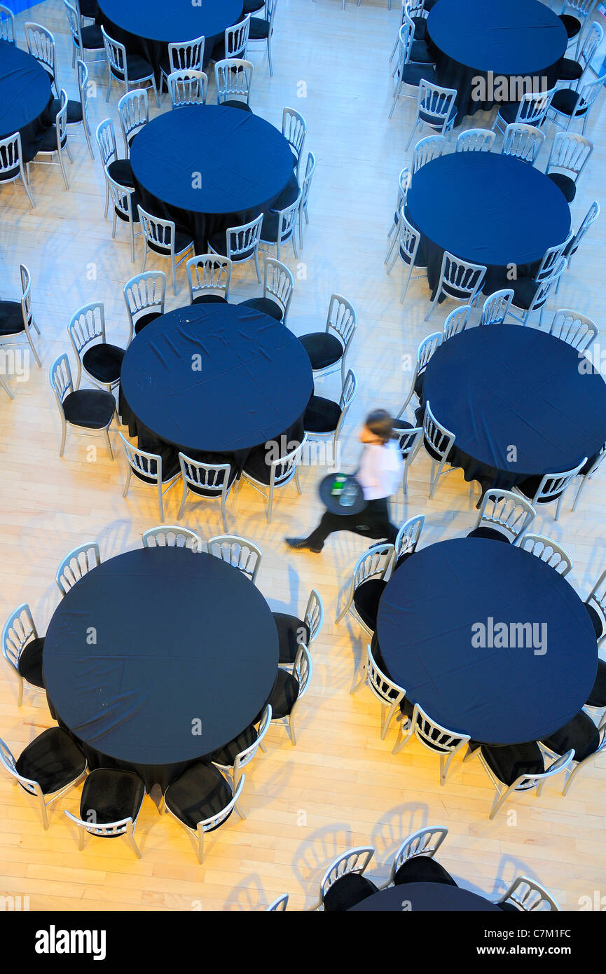 Overhead view of a restaurant with empty tables, a waiter passing ...