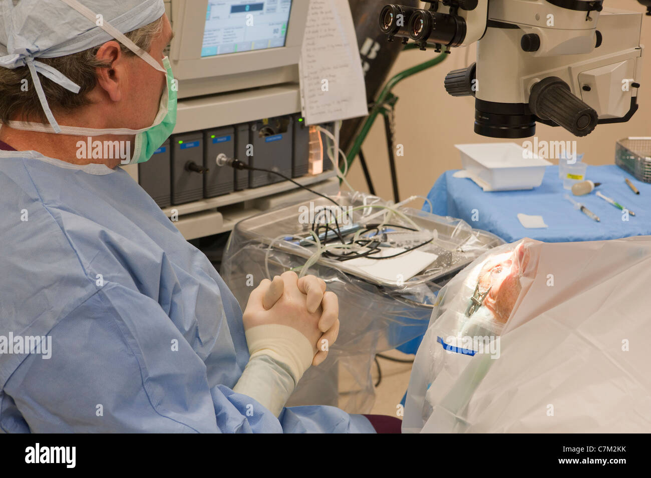 Ophthalmologist waiting for an instrument to perform cataract surgery ...