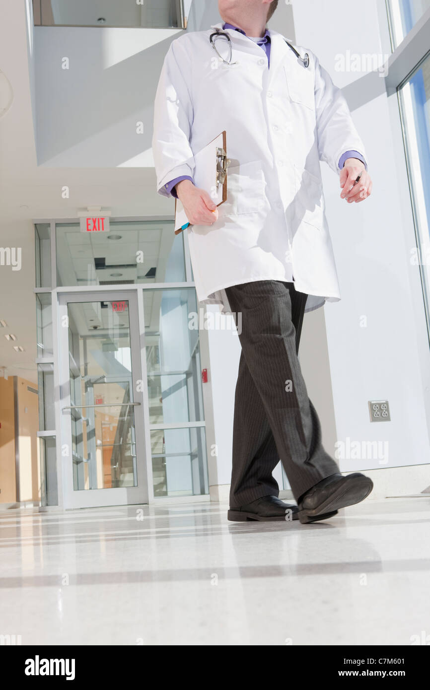 Male doctor walking in a corridor of a hospital Stock Photo - Alamy