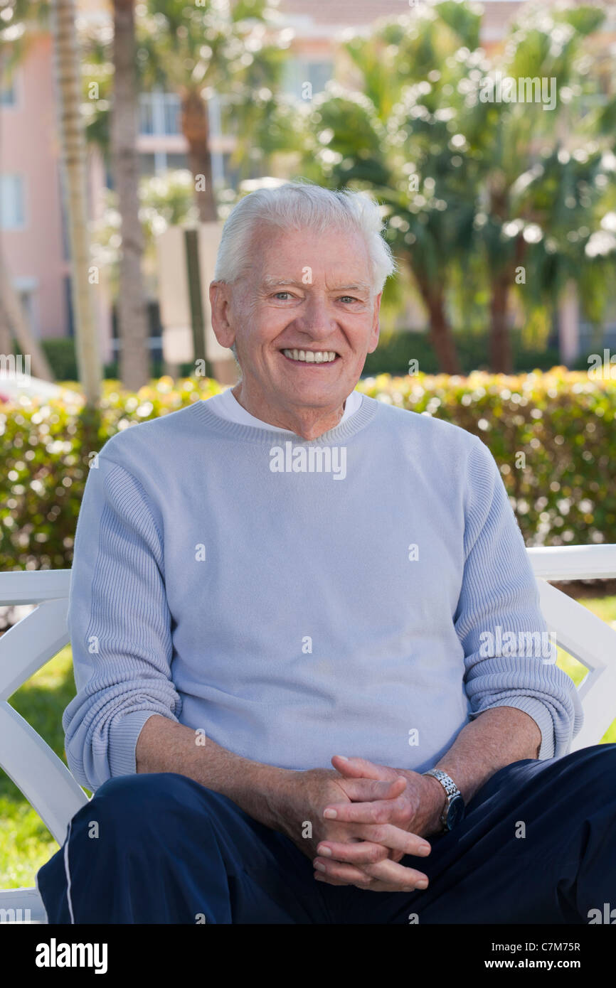 Portrait of a man sitting on a park bench and smiling Stock Photo - Alamy