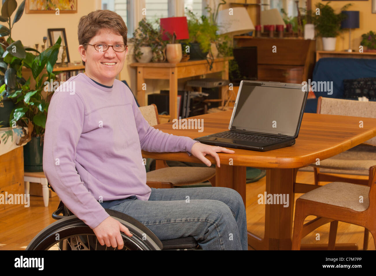 Woman with multiple sclerosis at a table with laptop Stock Photo - Alamy