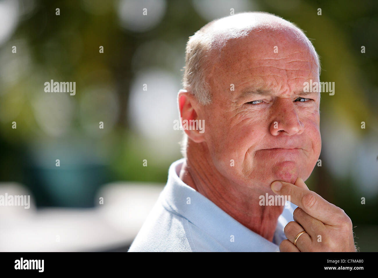 senior man holding his chin Stock Photo - Alamy