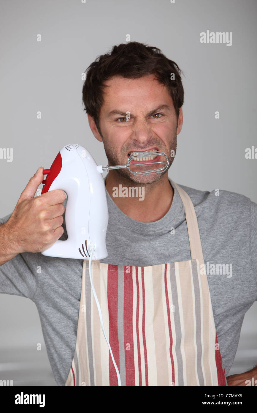 Aggressive chef wielding an electric hand mixer Stock Photo - Alamy